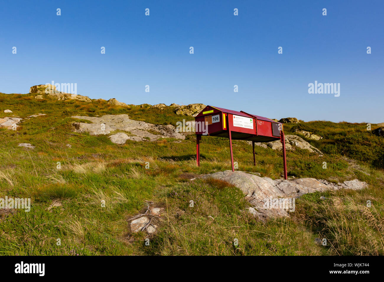 Red painted mountain rescue supply box on green hillside above Bergen ...