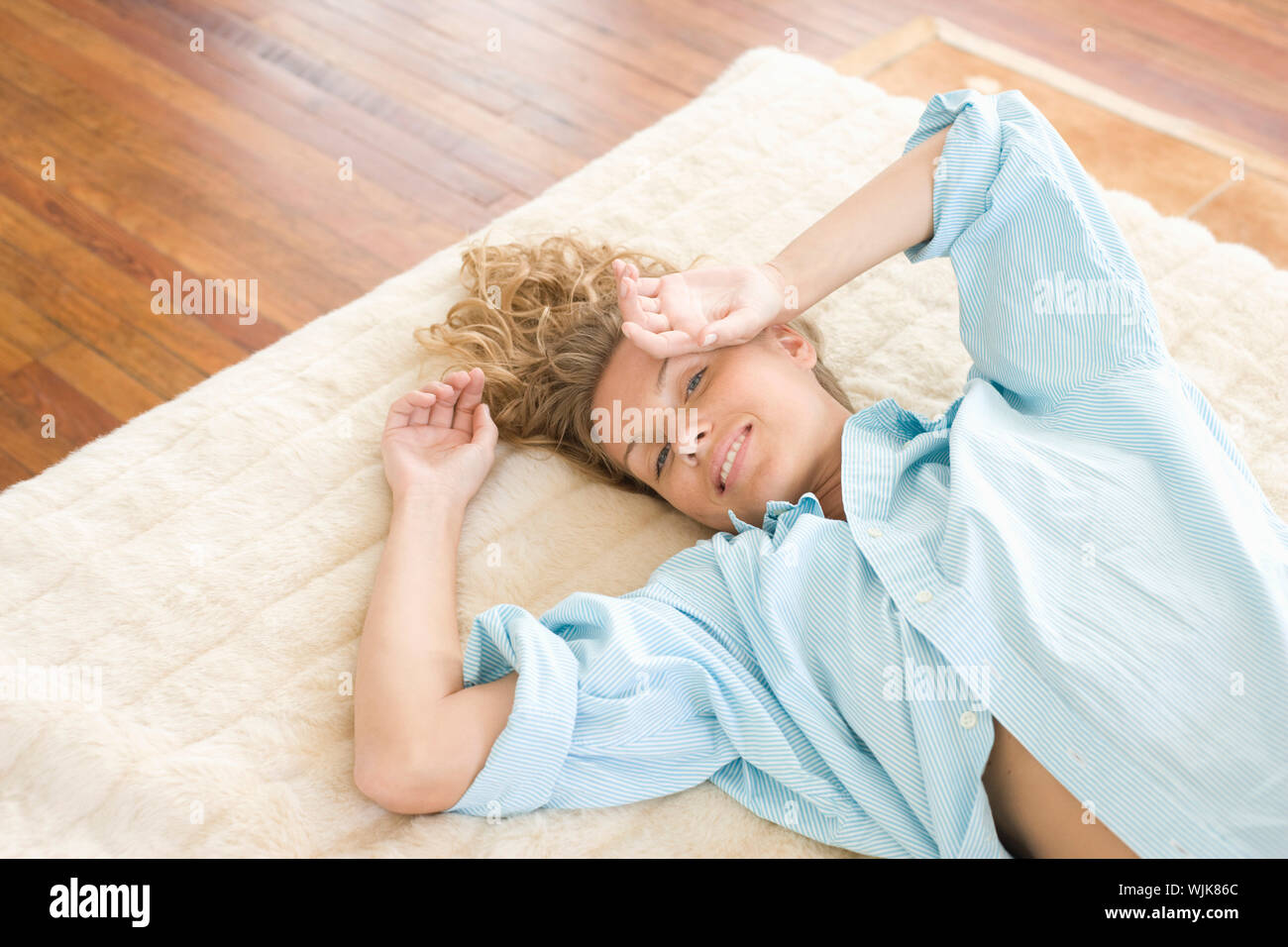 Portrait of beautiful young woman lying on rug at home Stock Photo - Alamy
