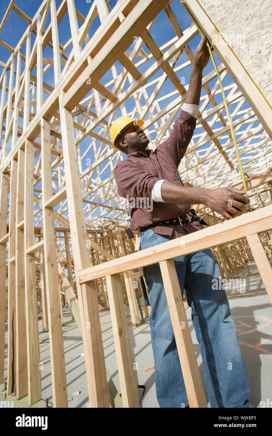 Construction worker measuring building Stock Photo - Alamy