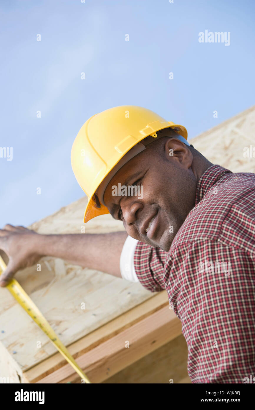 Construction worker measuring building Stock Photo - Alamy