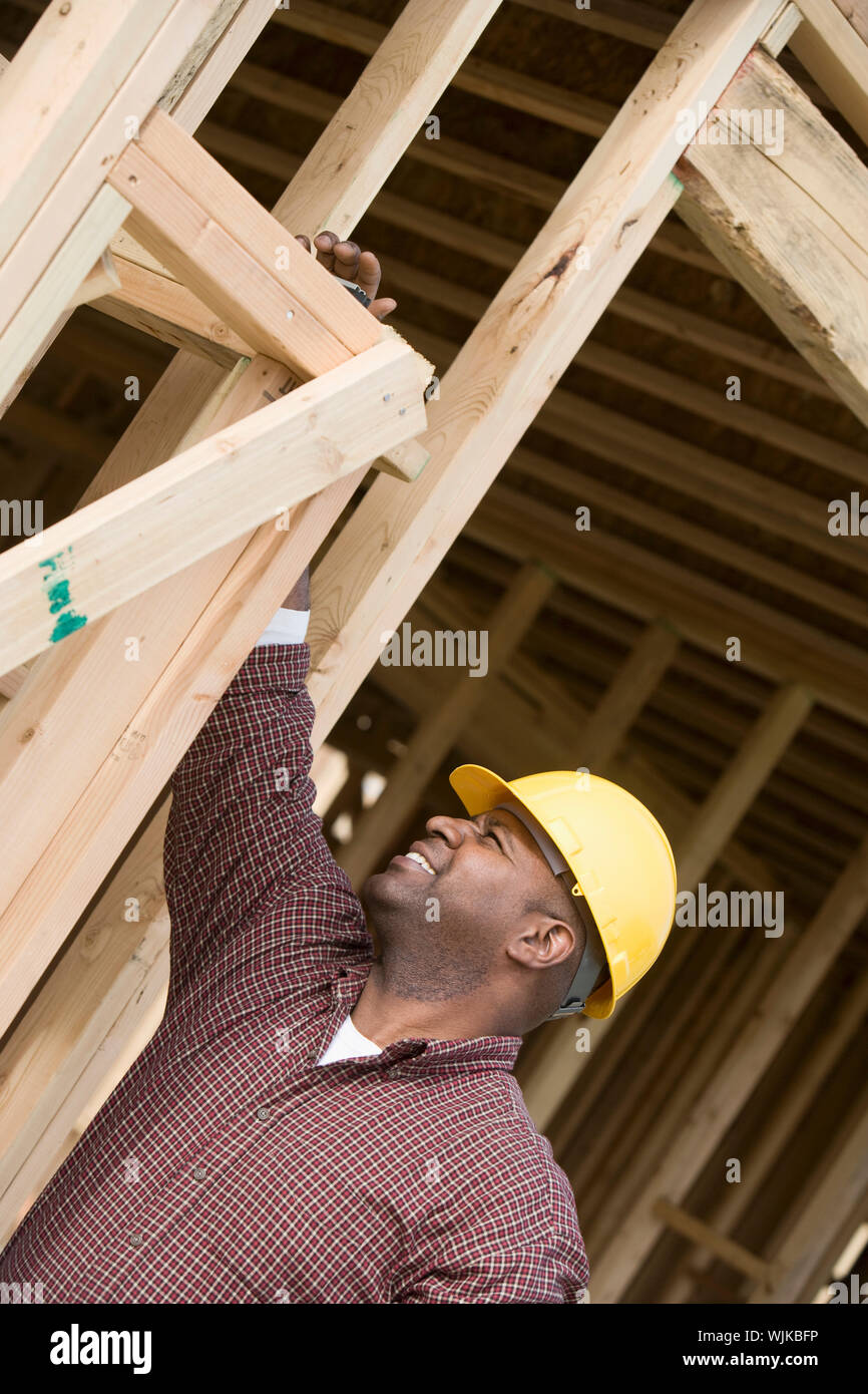 Construction worker measuring building Stock Photo - Alamy