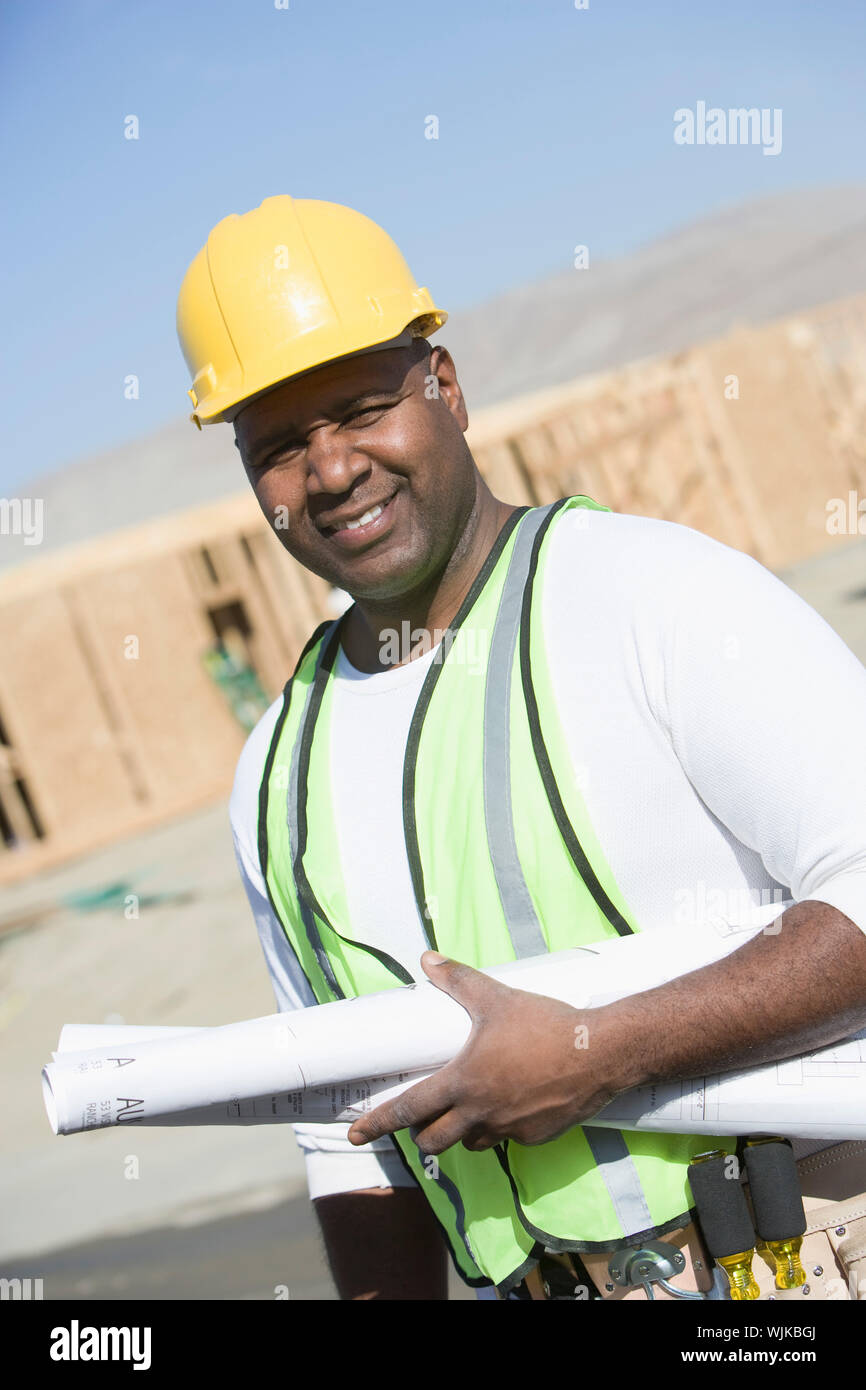 Construction worker holding blueprints Stock Photo - Alamy