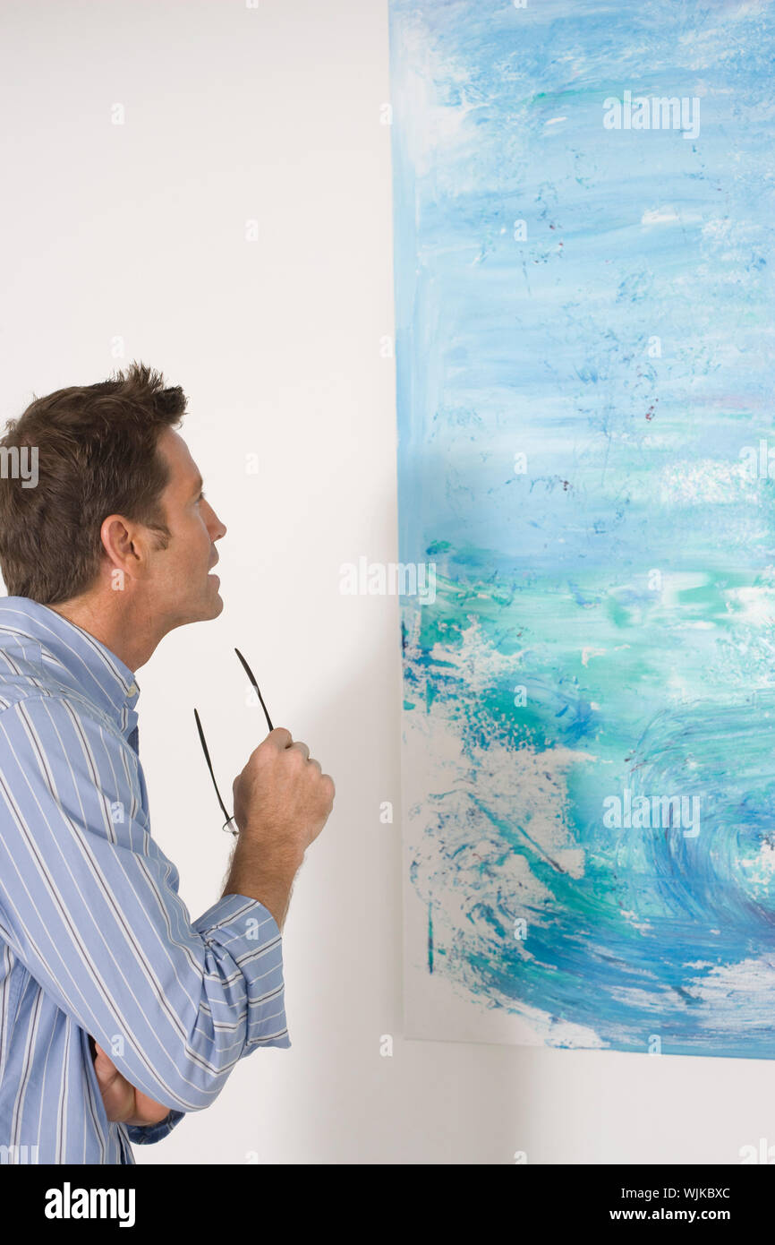 Side view of man observing painting in art gallery Stock Photo - Alamy