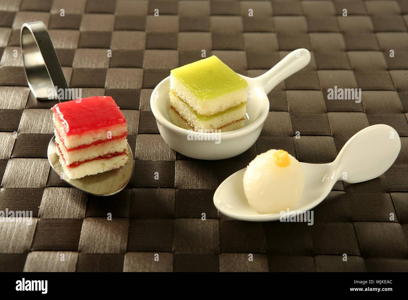 Varied pastries over spoon. Little colorful cakes Stock Photo - Alamy