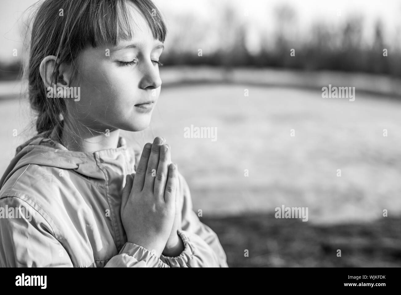 Young girl praying on the background of nature Stock Photo - Alamy