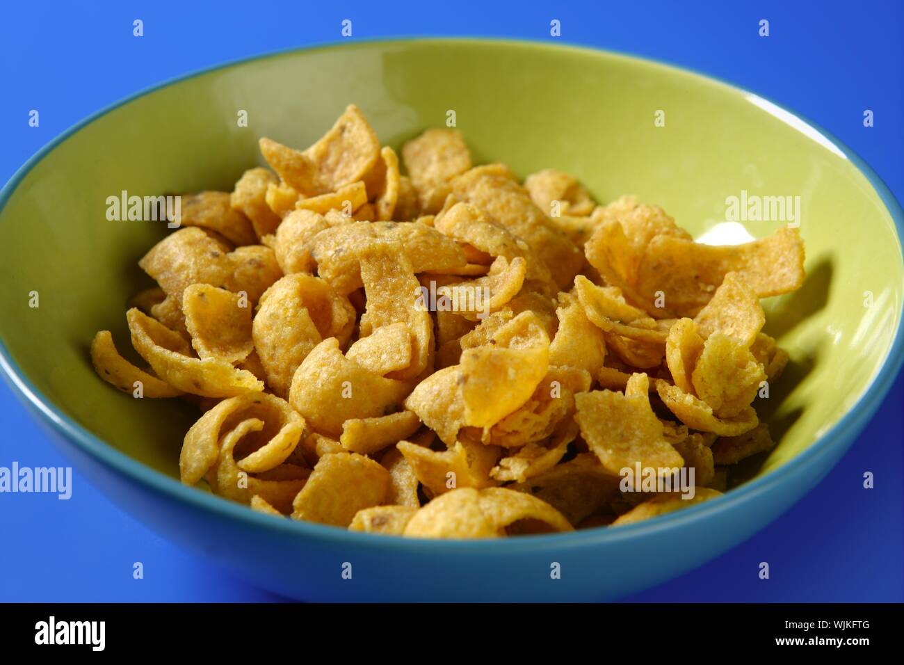 Fried corn golden snack in plate over blue background Stock Photo - Alamy