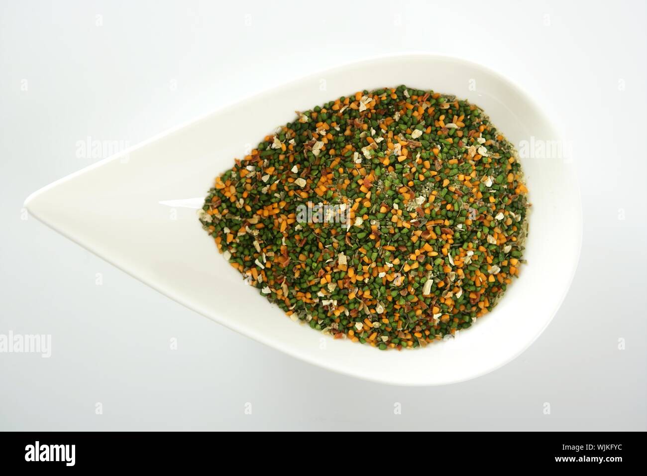 Multicolor vegetables semolina textures in white dish, white background ...