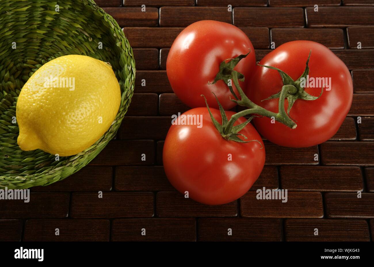 Varied fruits and vegetables, three tomatoes and yellow lemon Stock ...