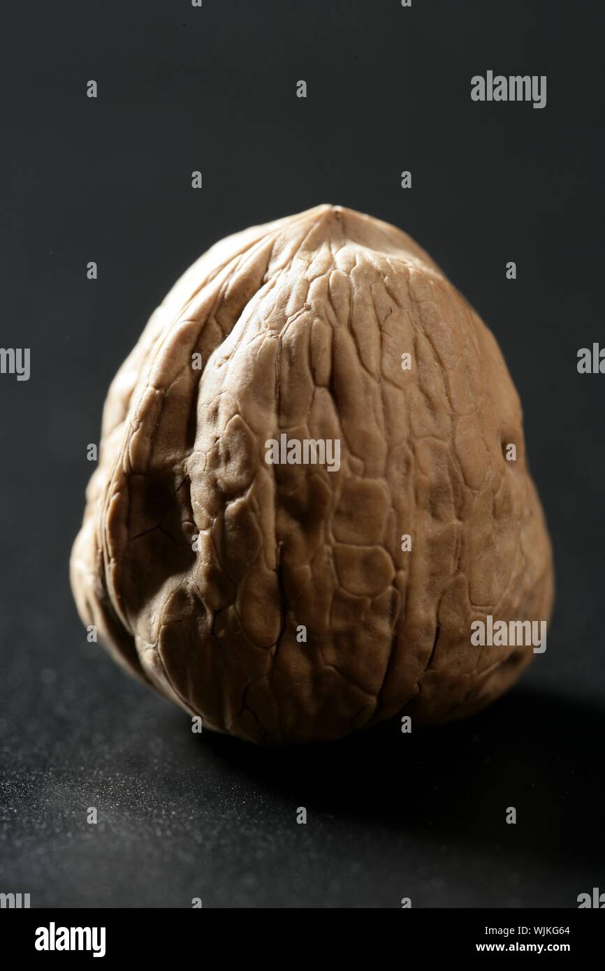 One walnut with shells over black background and shadows Stock Photo ...