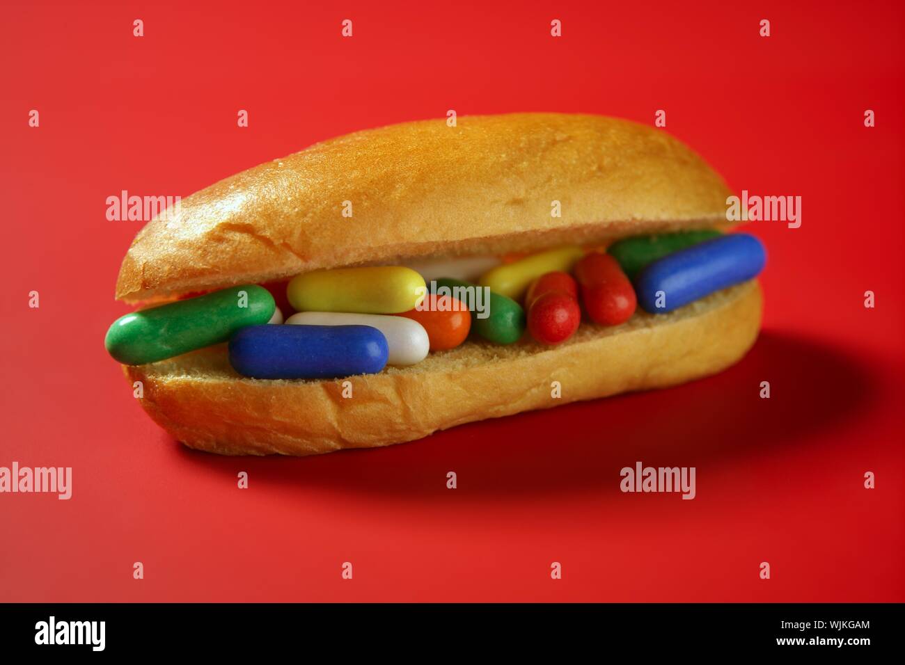 Candy sandwich sweet metaphor over red background Stock Photo - Alamy