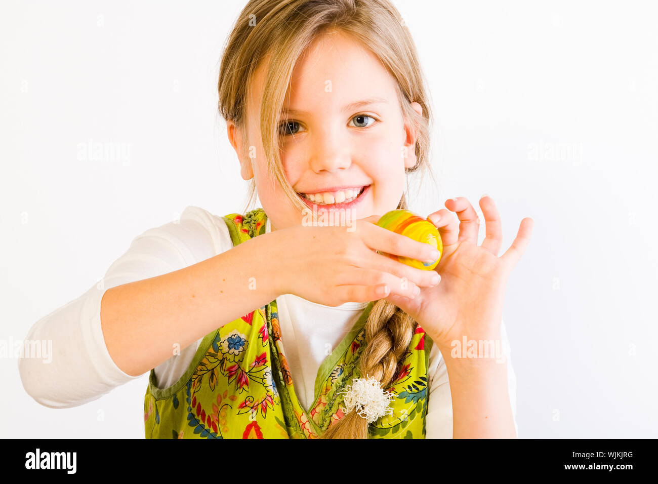 Studio portrait of a young blond girl who is presenting her painted ...