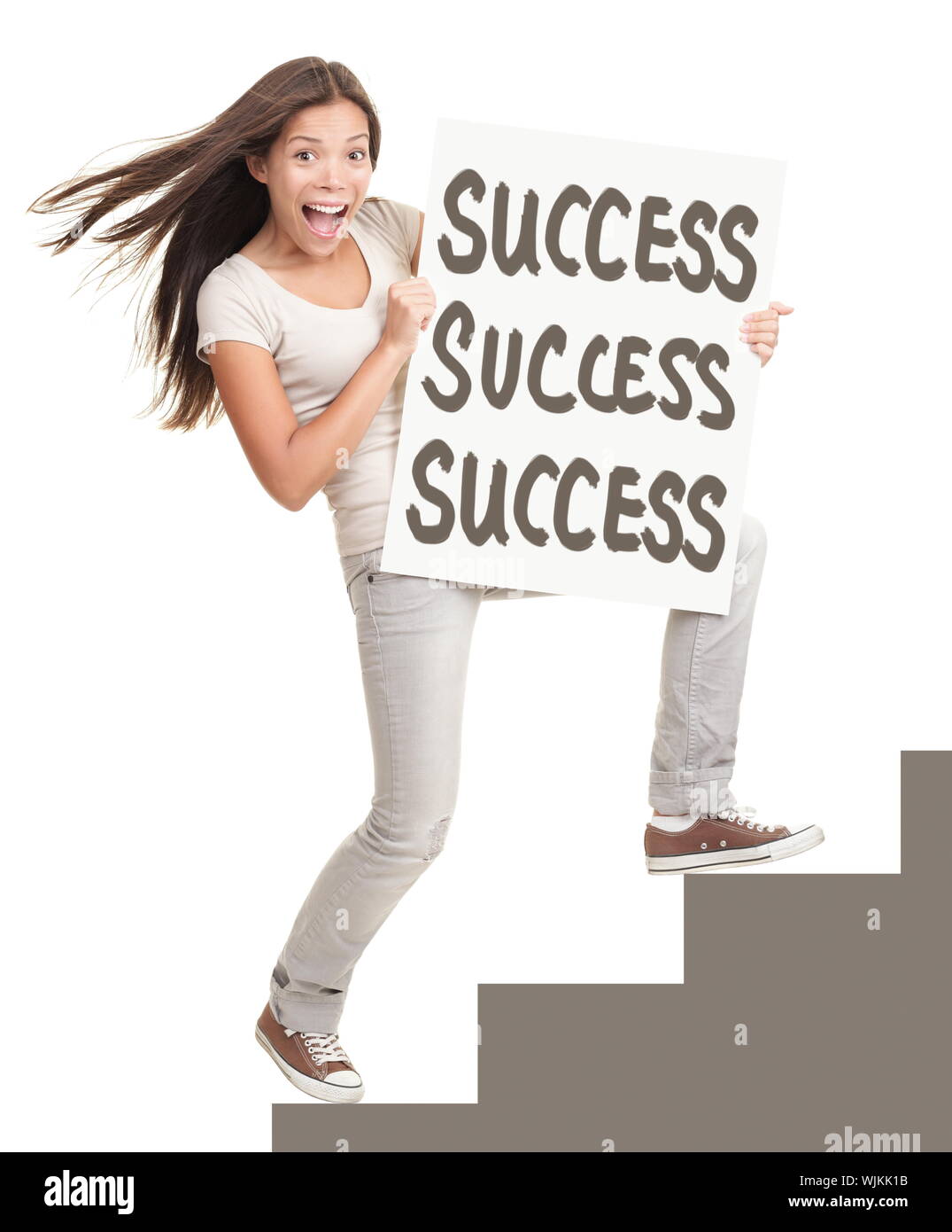 Success sign. Young successful woman showing success sign climbing ...