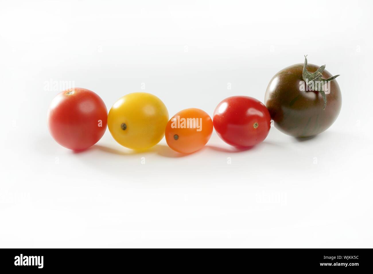 Little cherry varied multi color tomatoes, at studio, white background ...