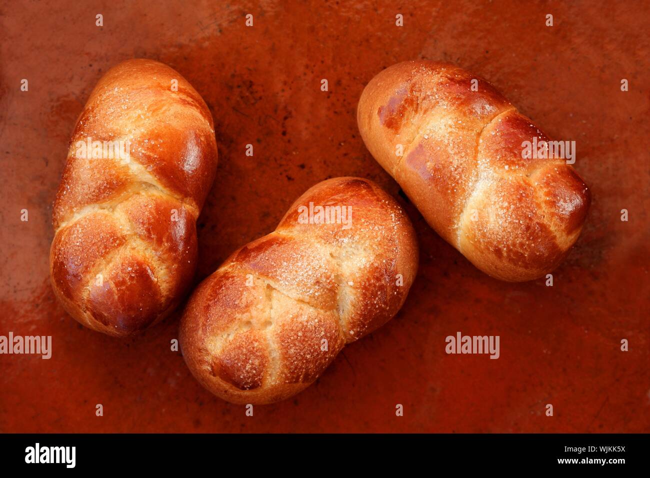 Three brioche pastries over orange brown clay background, bakery Stock ...