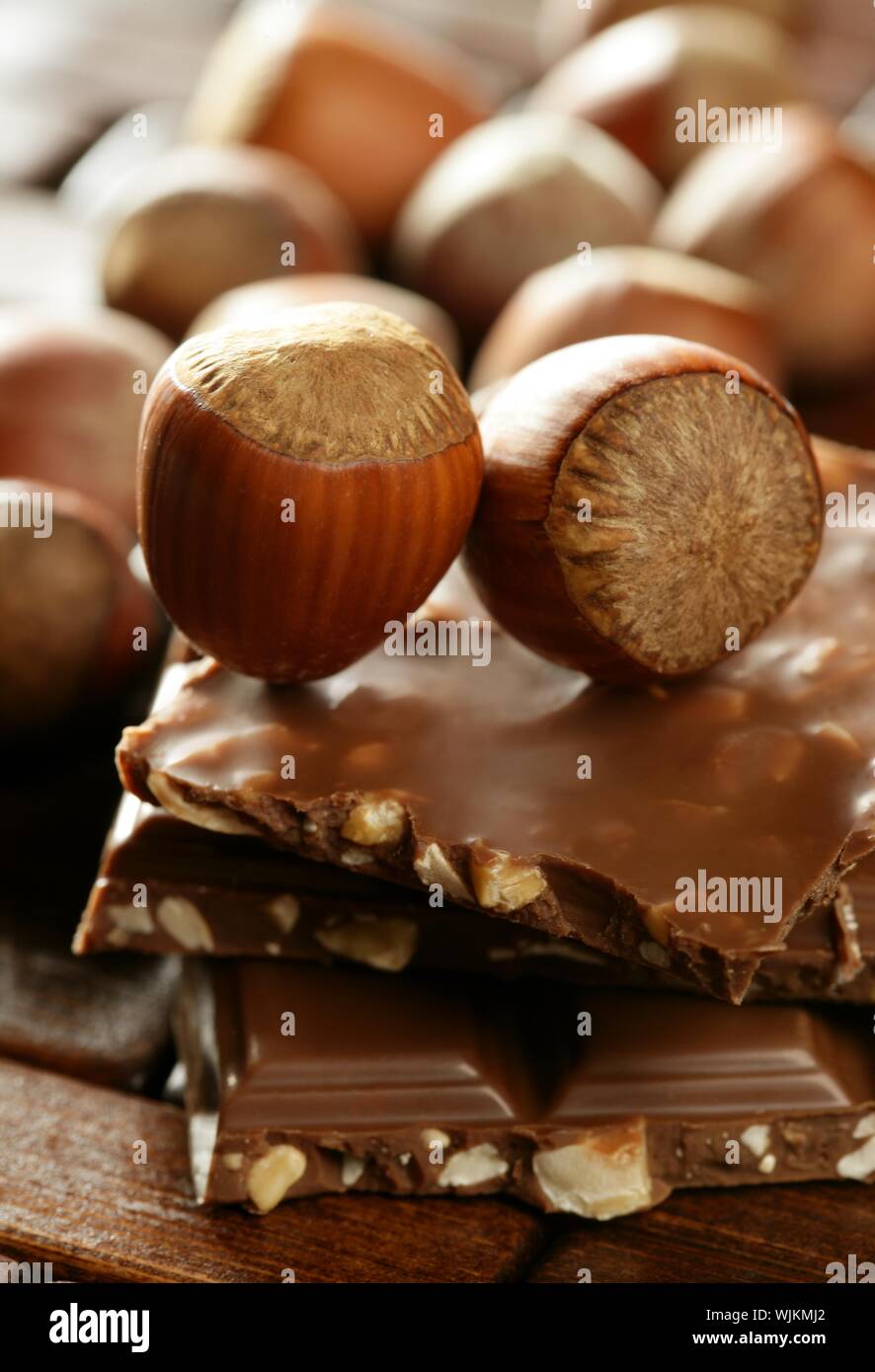 Hazelnuts and chocolate on brown wood enviroment at studio Stock Photo - Alamy