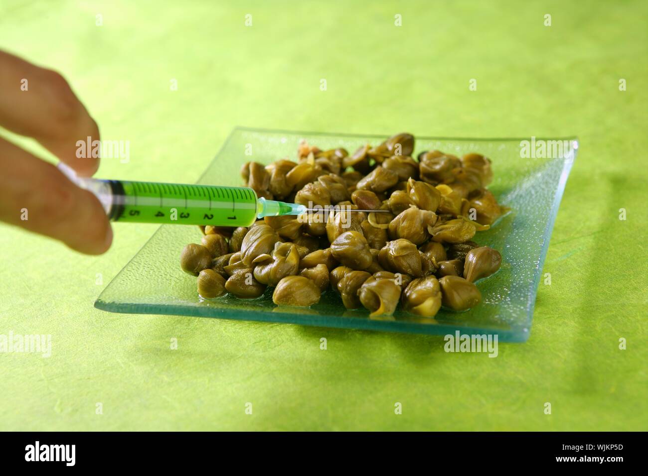 Food research metaphor with green syringe and tapera dish Stock Photo ...