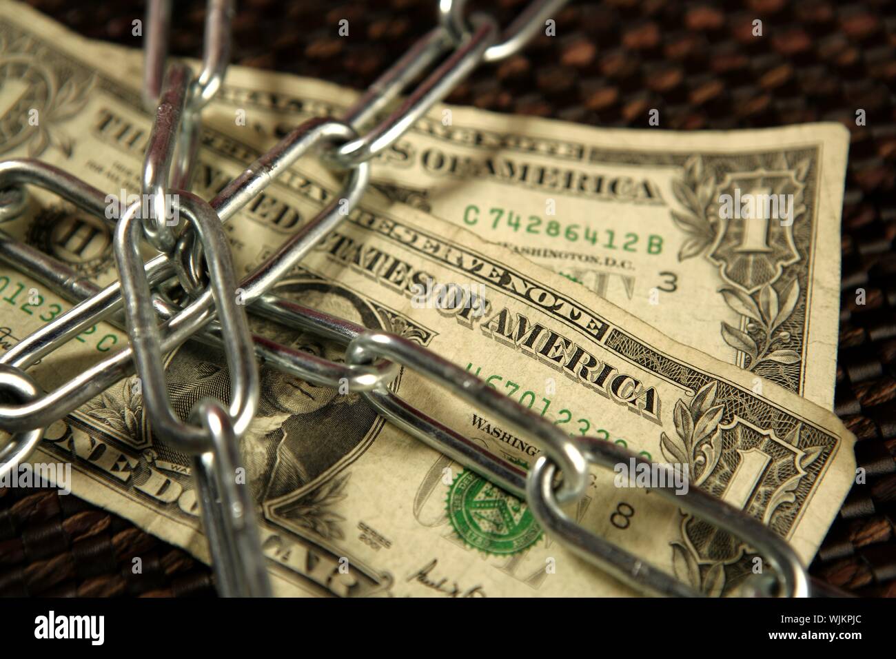 One Dollar notes in chains studio shot over brown background Stock ...