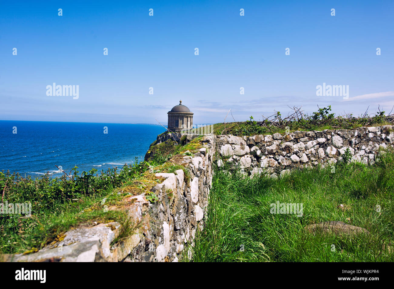 Mussenden Temple against blue sky and Atlantic ocean on the North ...