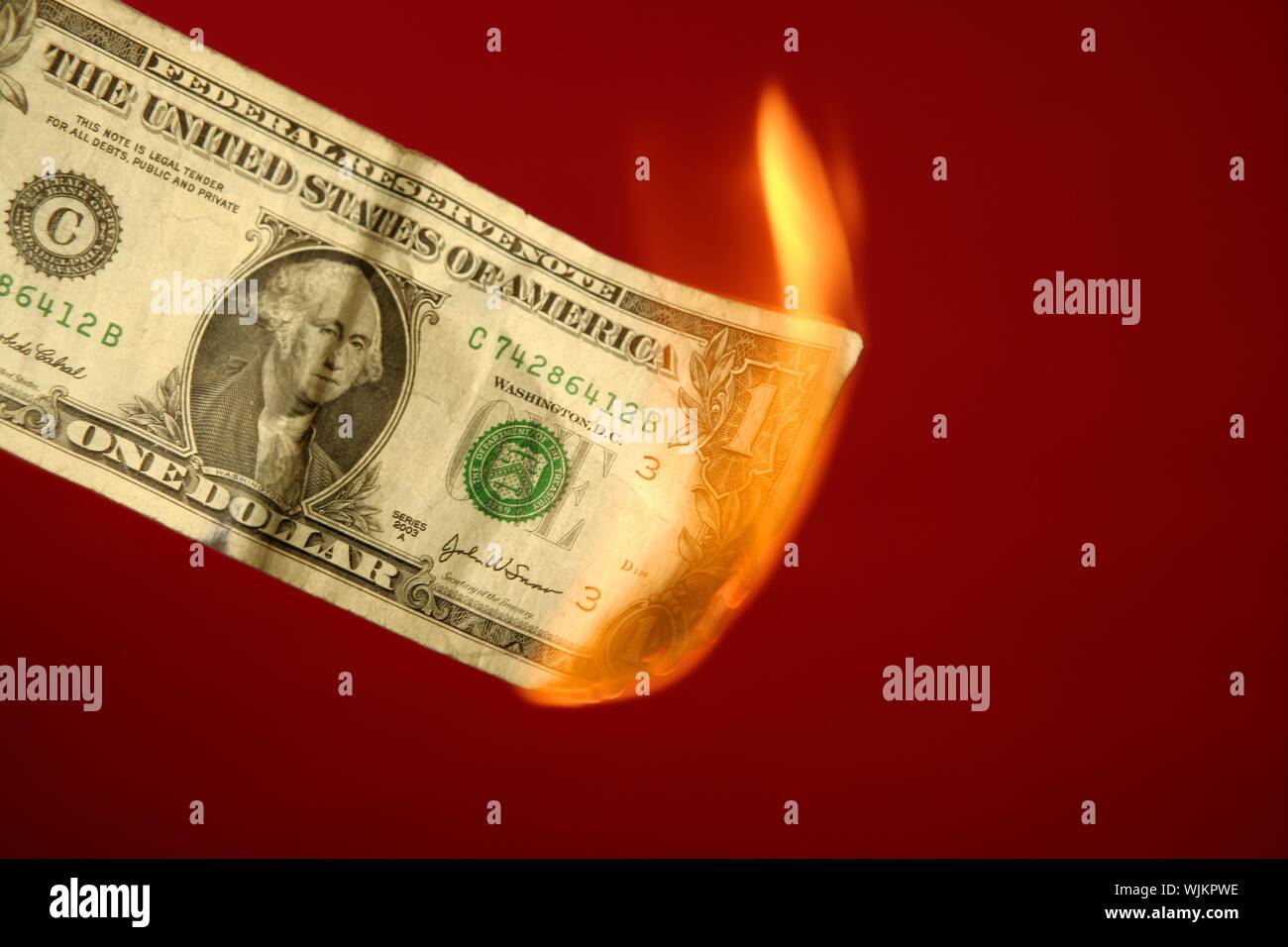 Dollar note, american currency burning in fire over red background ...
