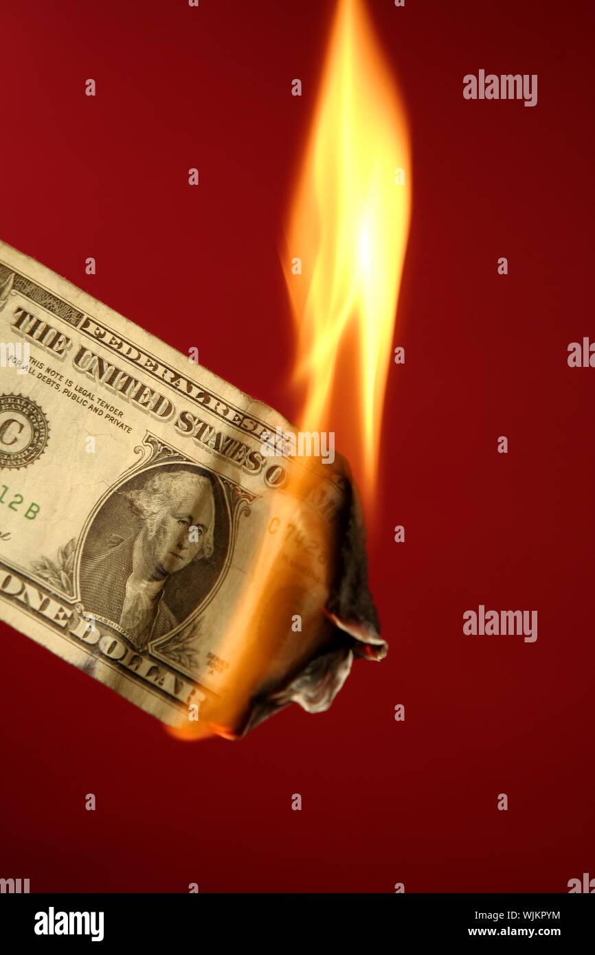 Dollar note, american currency burning in fire over red background ...