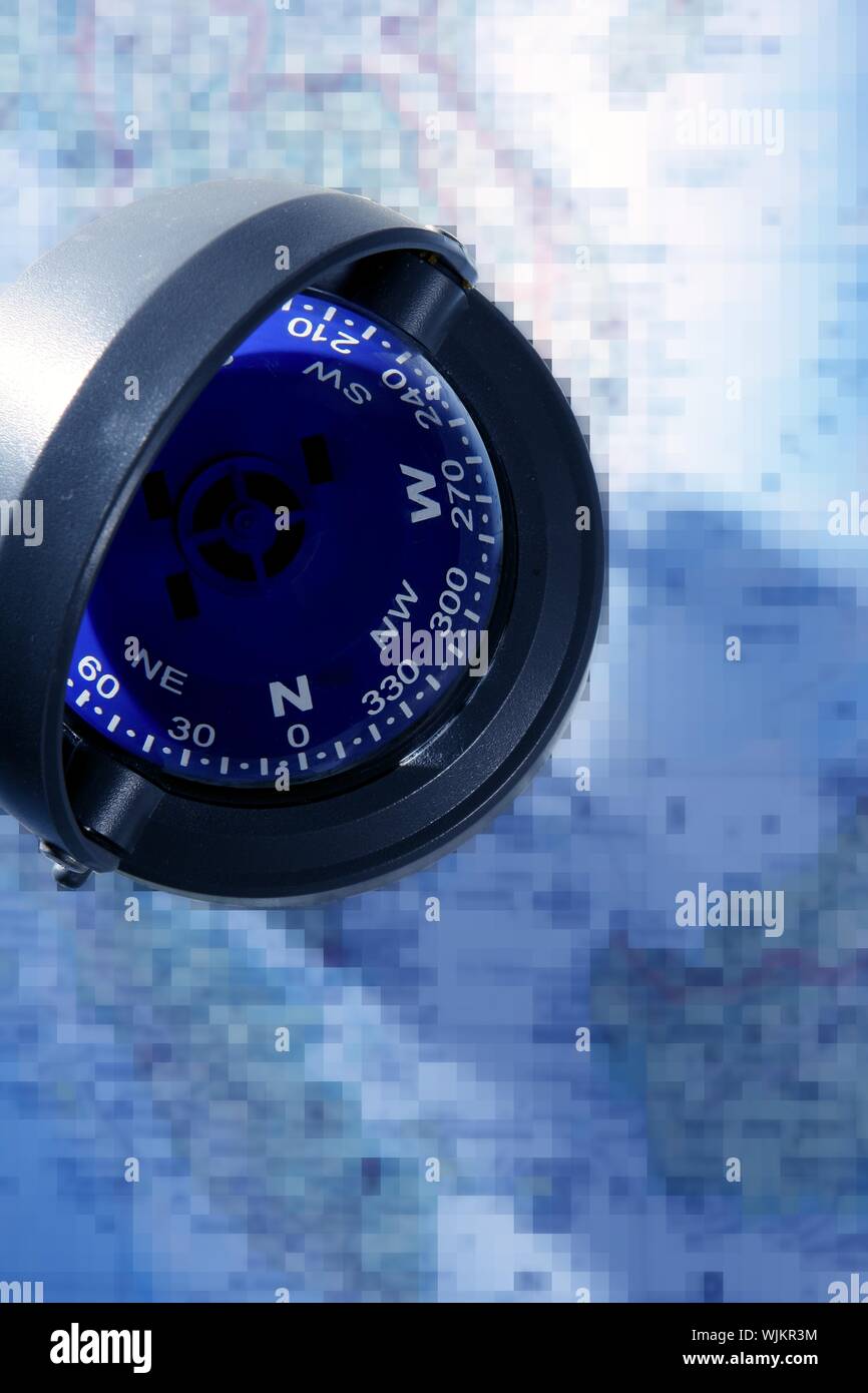 Nautical compass over a blue chart map, travel metaphor Stock Photo - Alamy