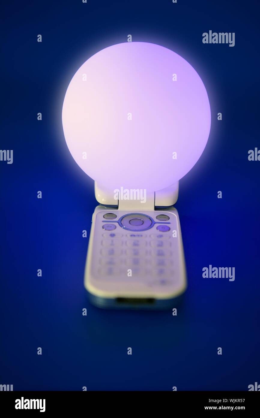Glowing light sphere on mobile cellphone communications metaphor Stock ...