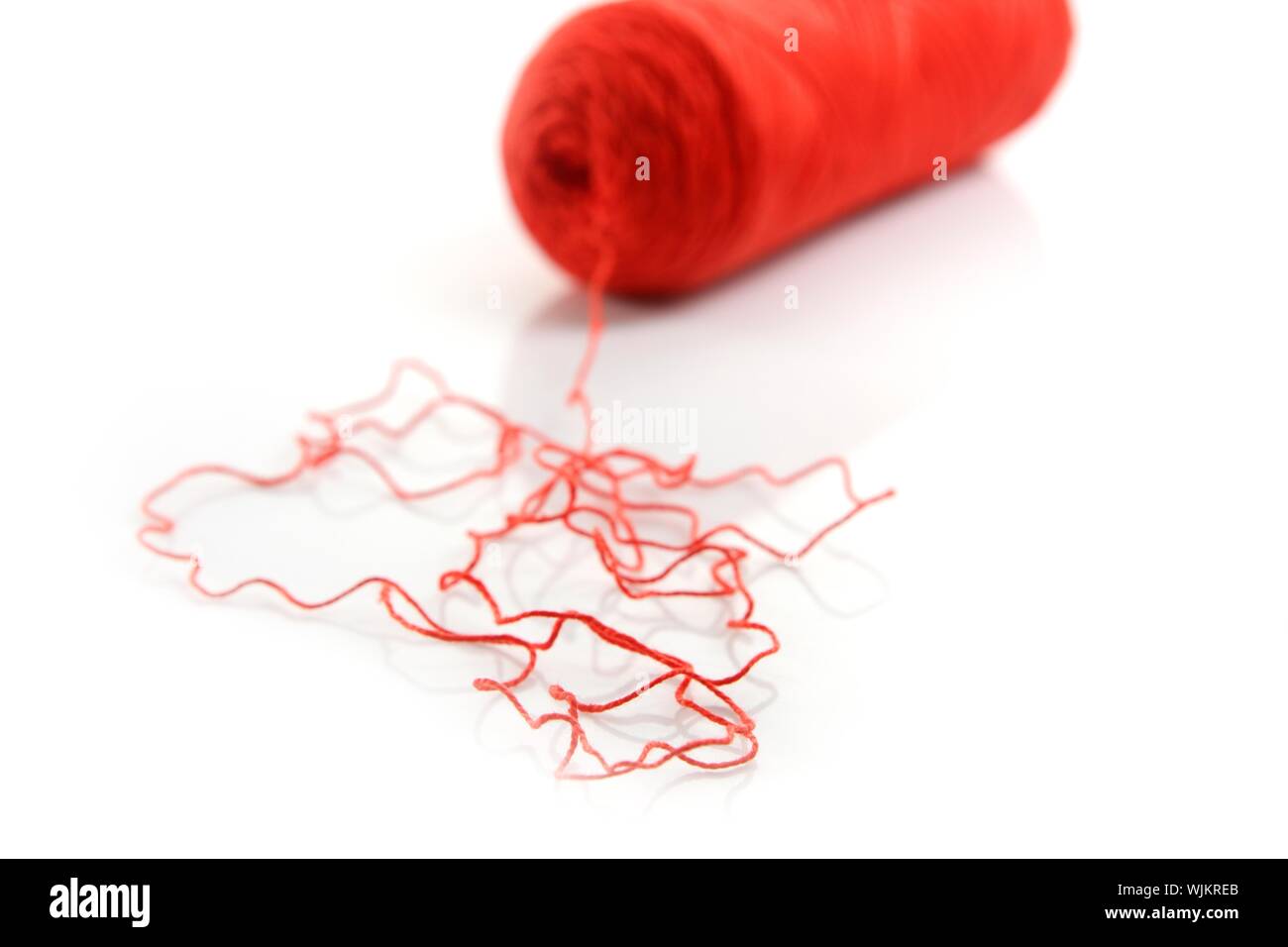 Red thread spool isolated over white studio background Stock Photo - Alamy