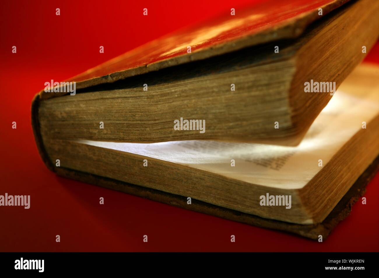 Old aged book close up, light glowing inside, over red background Stock ...