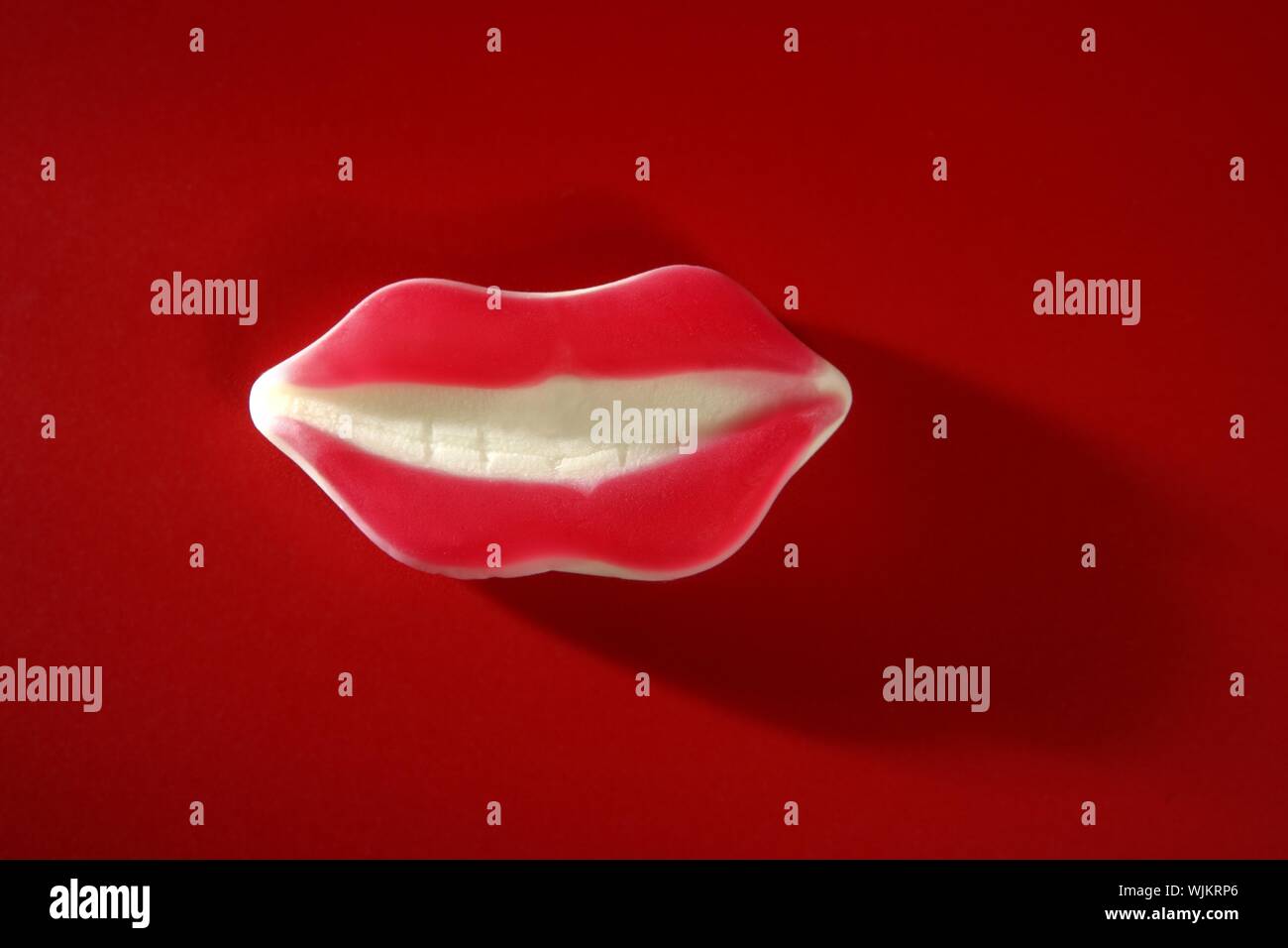 Candy gum jelly toy lips over red studio background Stock Photo - Alamy