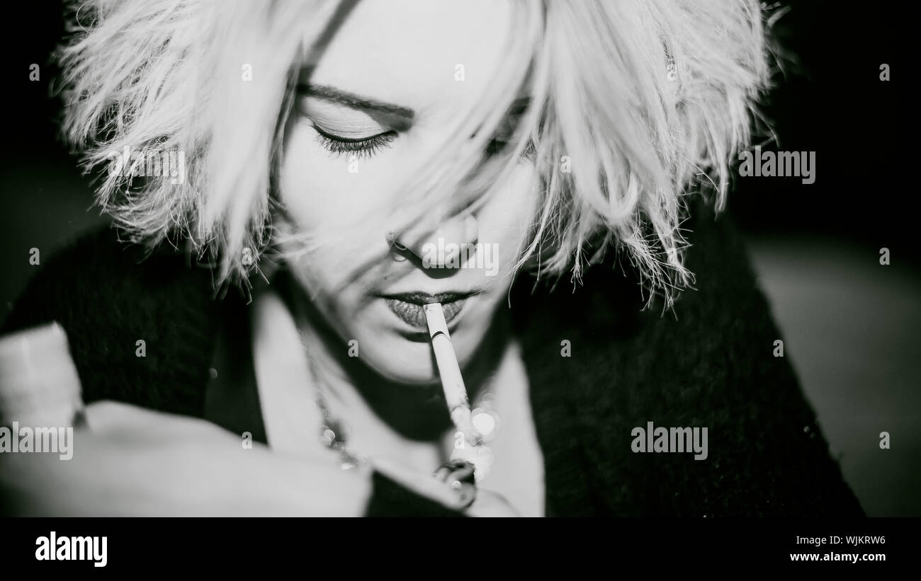 Woman lighting cigarette hi-res stock photography and images - Alamy