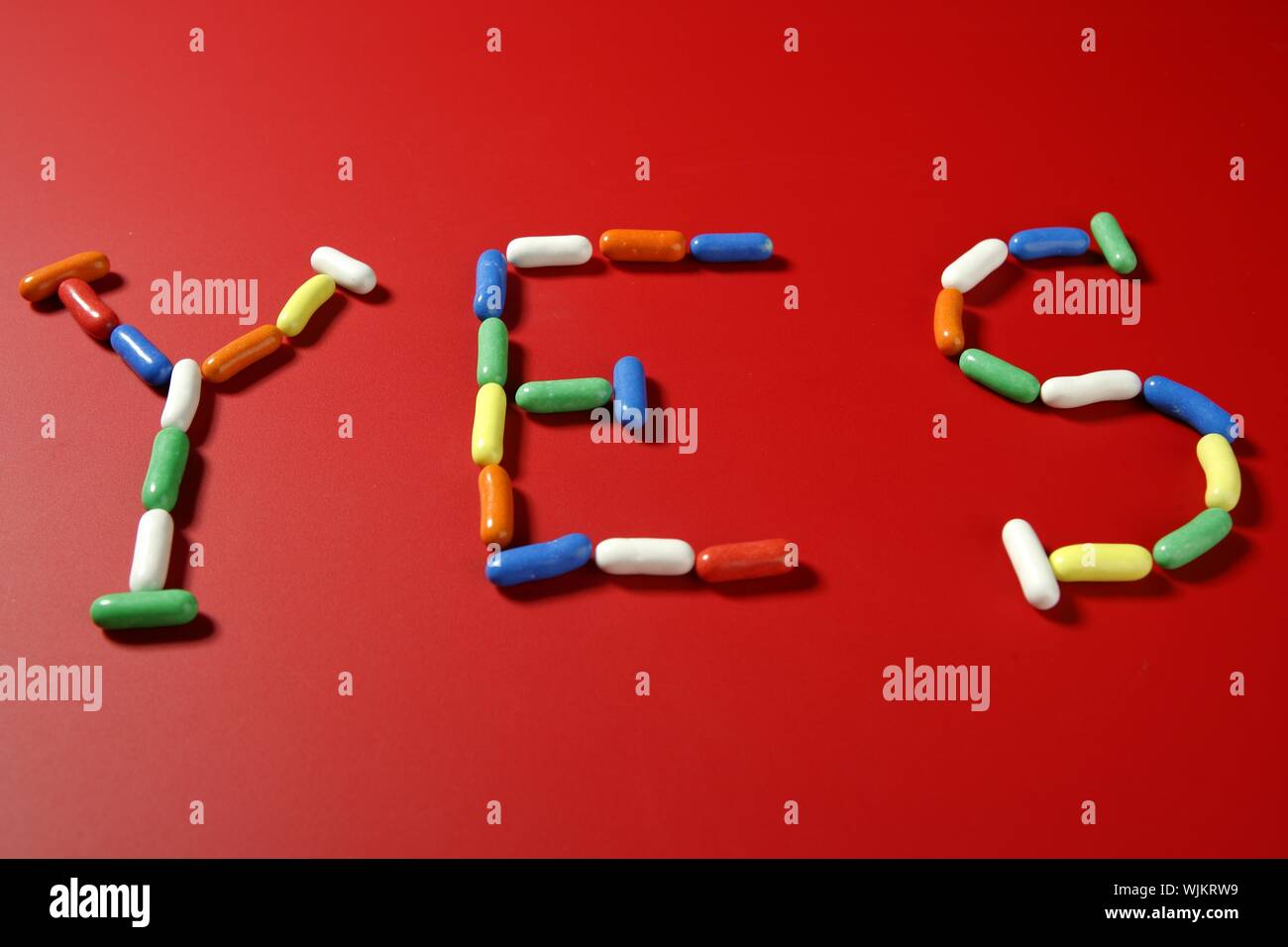 Candy colorful sweets with letter shapes spelling the word YES, over ...