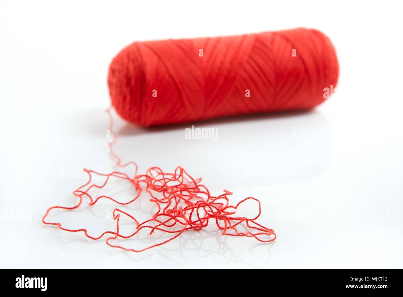 Red thread spool isolated over white studio background Stock Photo - Alamy