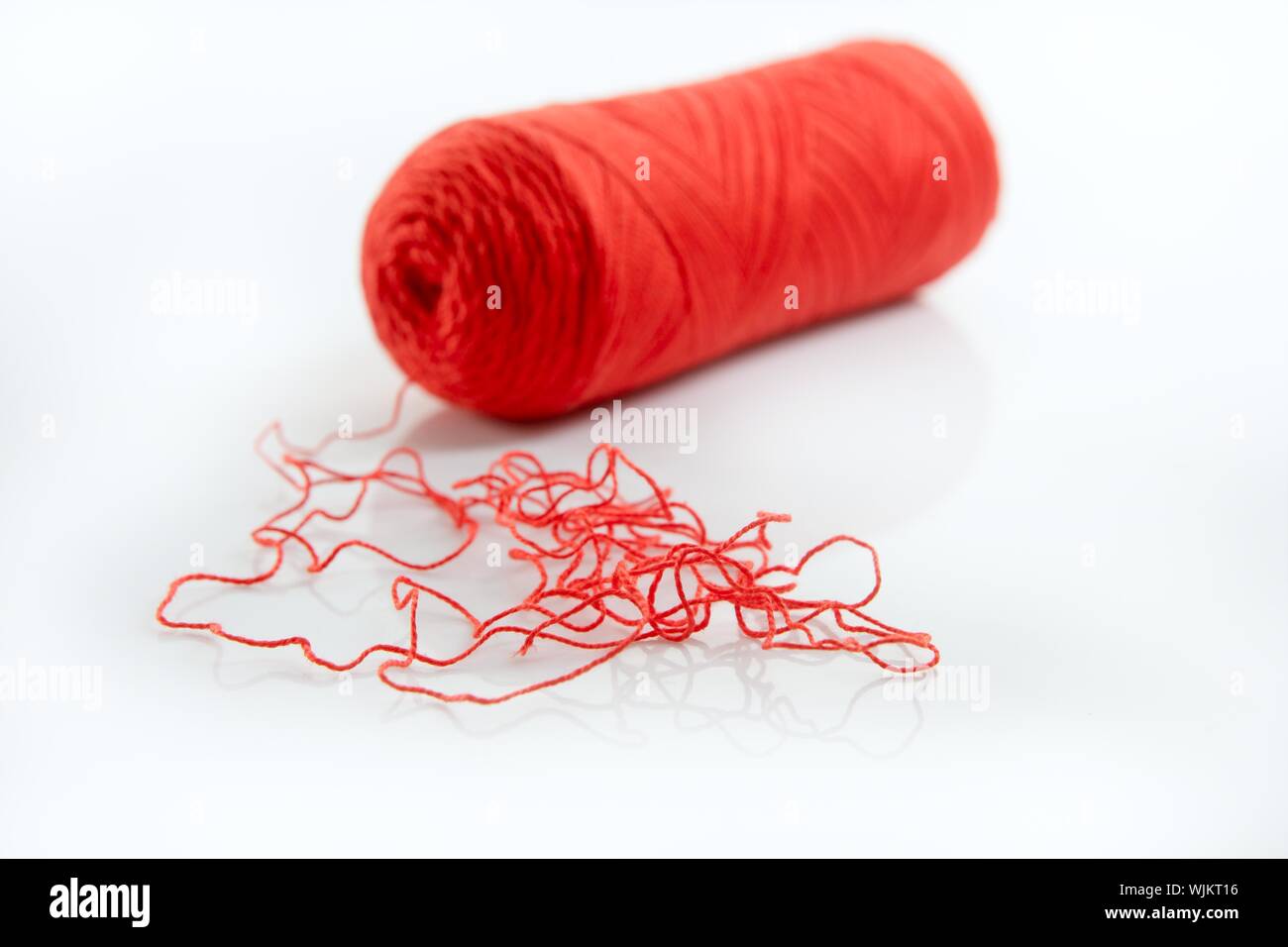 Red thread spool isolated over white studio background Stock Photo - Alamy