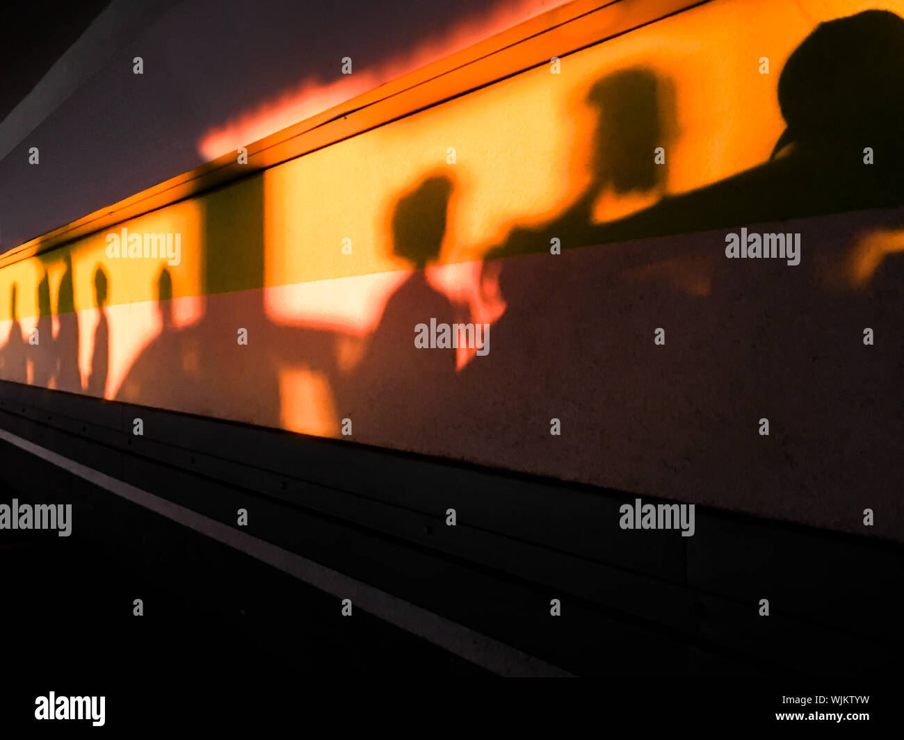 Shadow Of People On Illuminated Wall At Night Stock Photo - Alamy