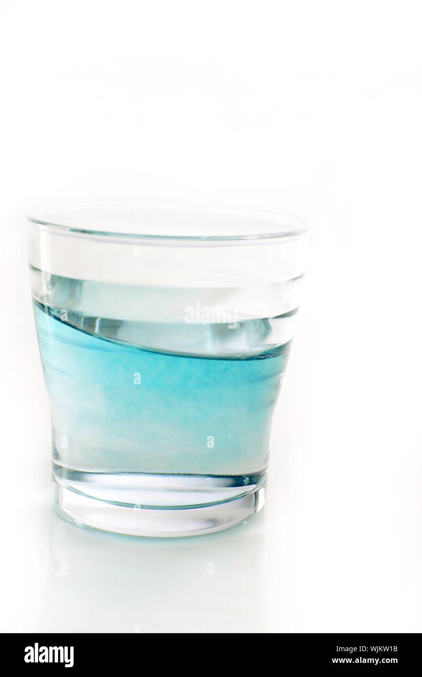 Glass of blue turquoise color moving water, isolated on white ...
