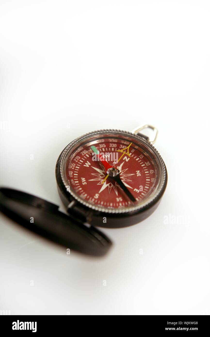 Red open magnetic compass, white background Stock Photo - Alamy