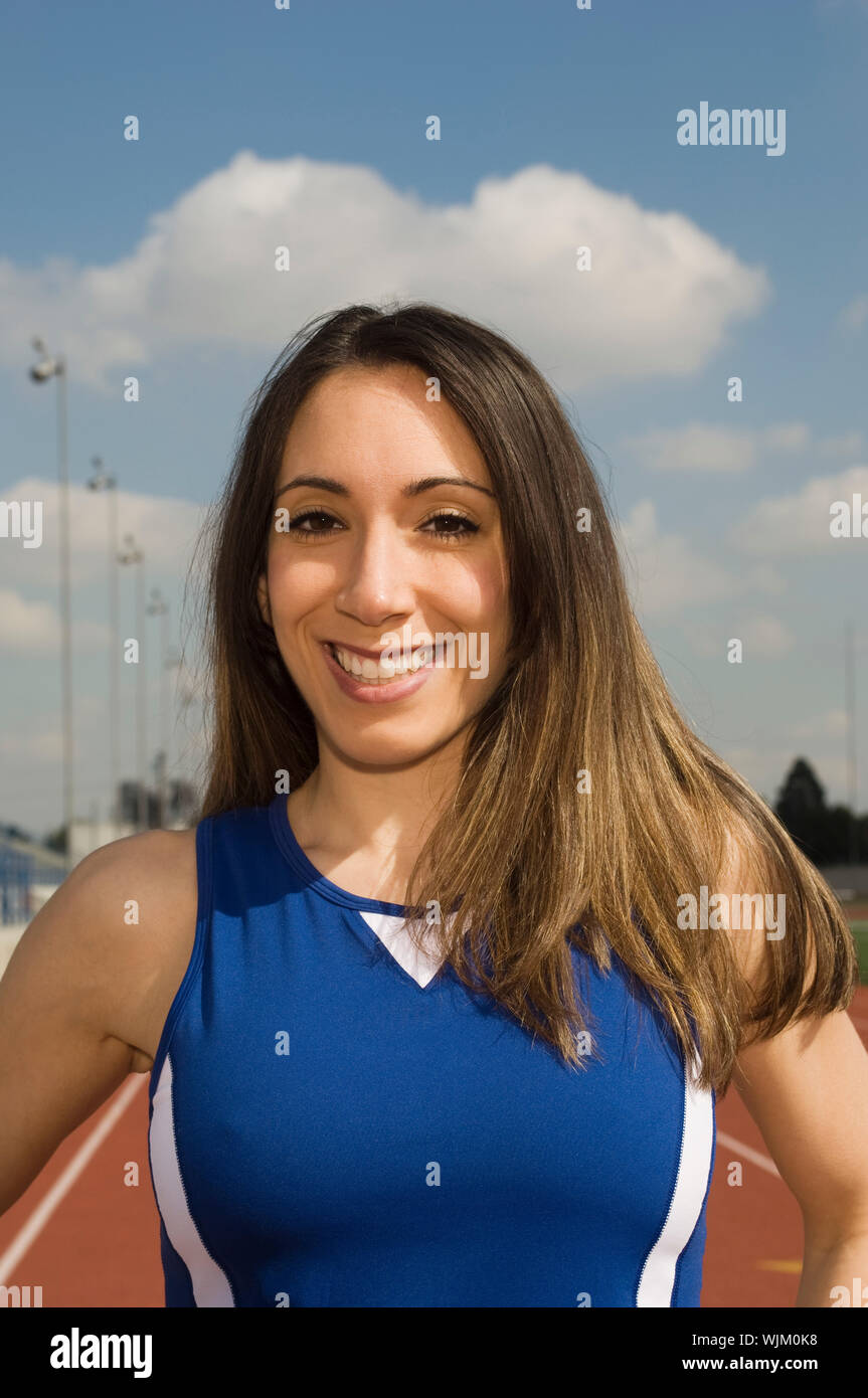 Female track athlete standing on track, portrait Stock Photo - Alamy