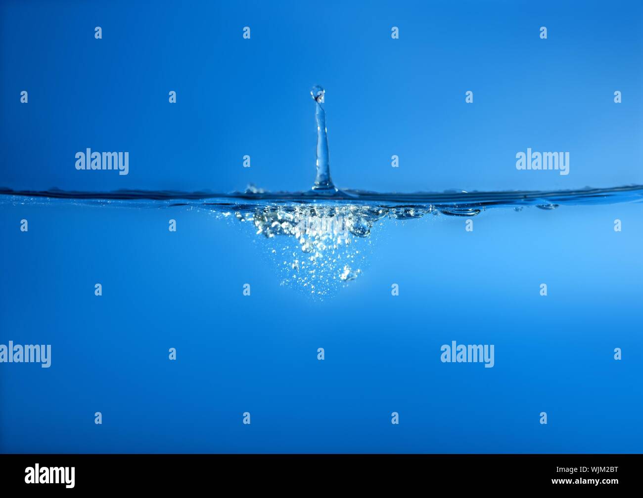 Splash on the blue water surface on side view Stock Photo - Alamy