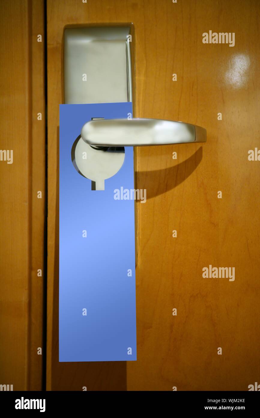 Hotel door handle with a copy space blue paper note, do not disturb ...