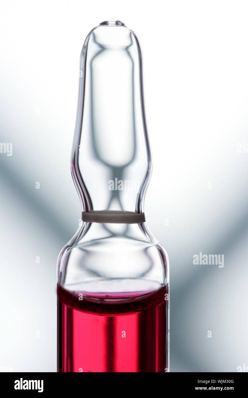 Glass ampoule with red liquid medicine inside Stock Photo - Alamy