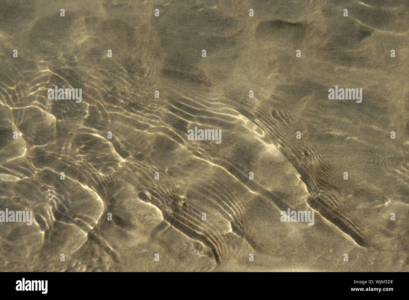 Reflexions on water surfase, beach sand bottom Stock Photo - Alamy