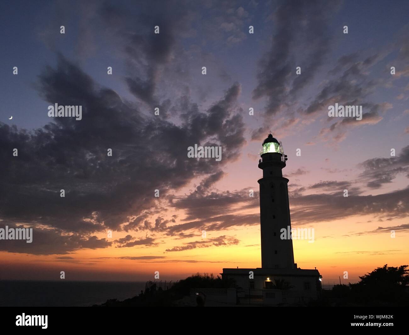 Trafalgar lighthouse on the coast of Cadiz at sunset Stock Photo - Alamy