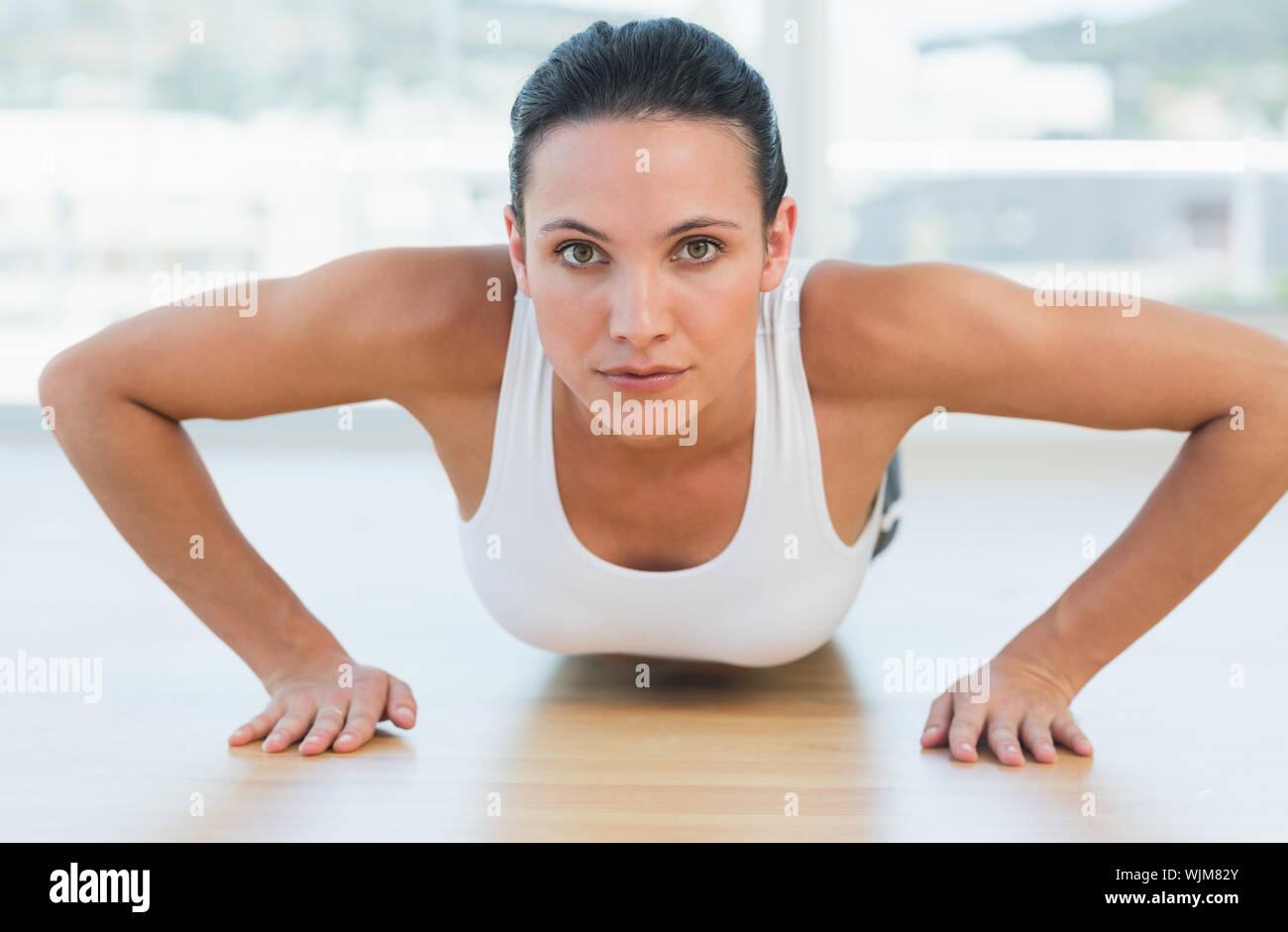 Determined beautiful young woman doing push ups in the gym Stock Photo ...