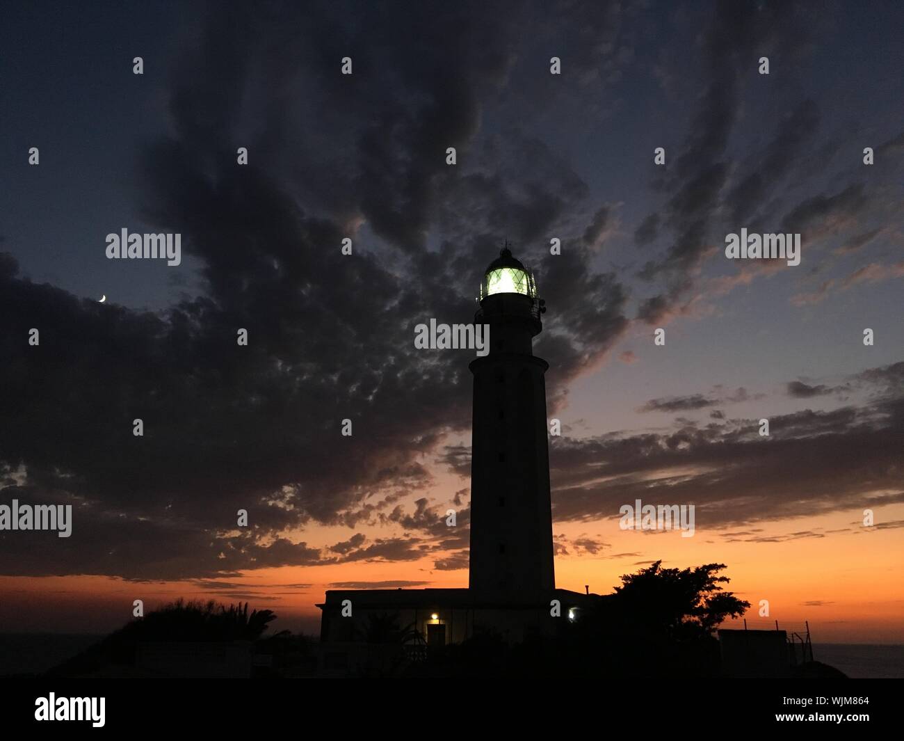 Trafalgar lighthouse on the coast of Cadiz at sunset Stock Photo - Alamy