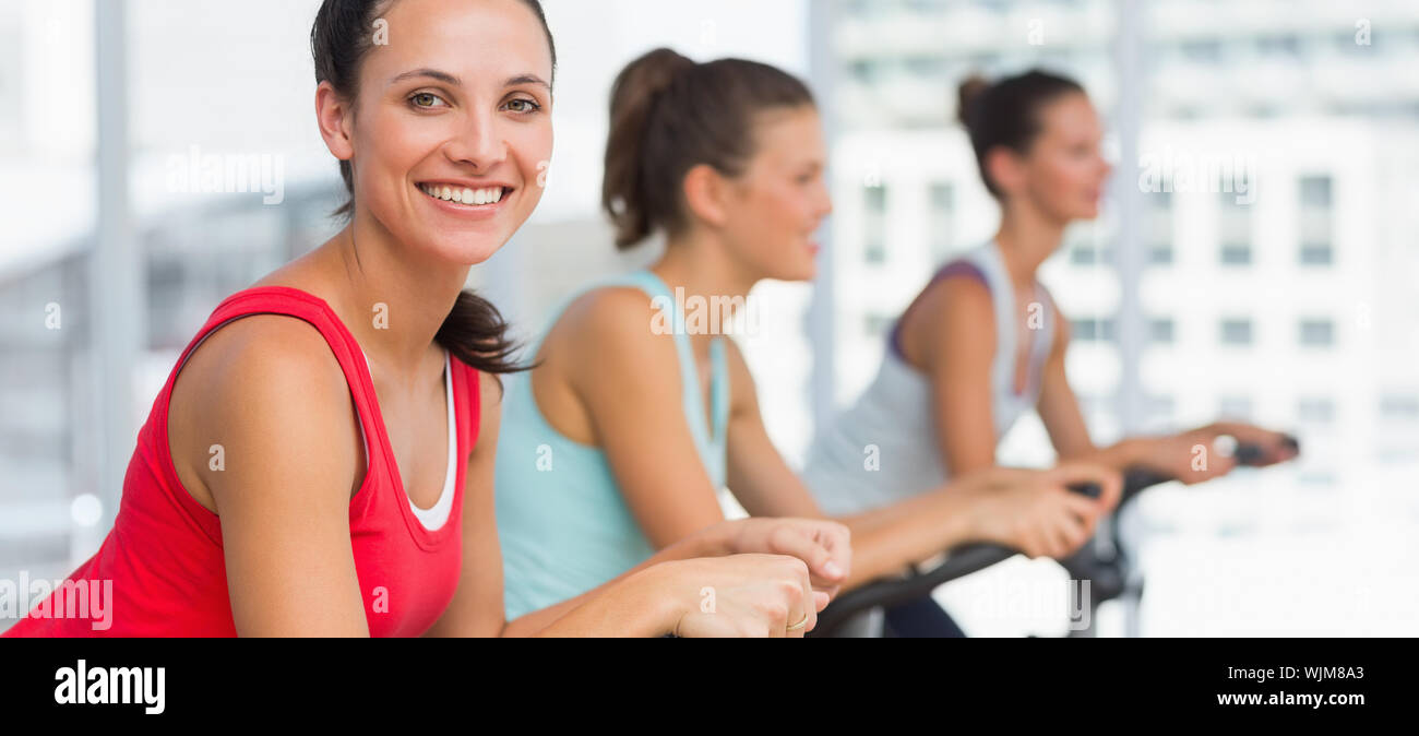 Side view portrait of fit young people working out at spinning class in ...