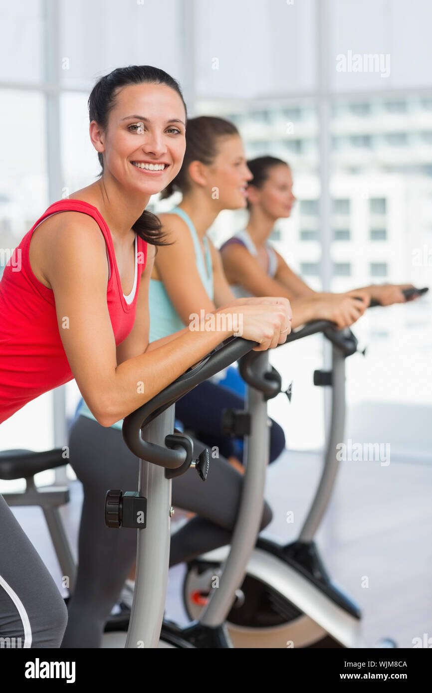 Side view portrait of fit young people working out at spinning class in ...