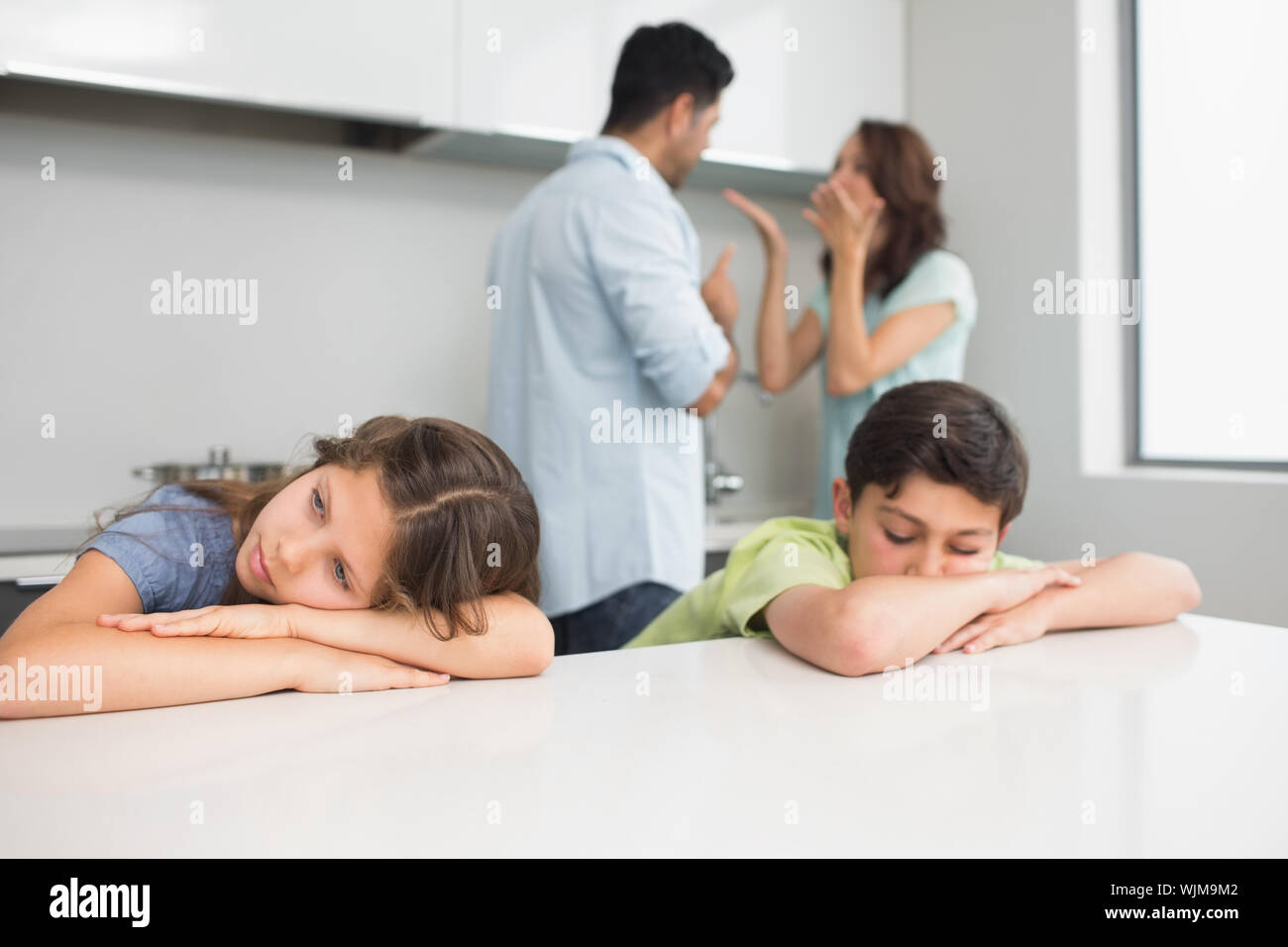 Sad young kids while parents quarreling in the kitchen at home Stock ...