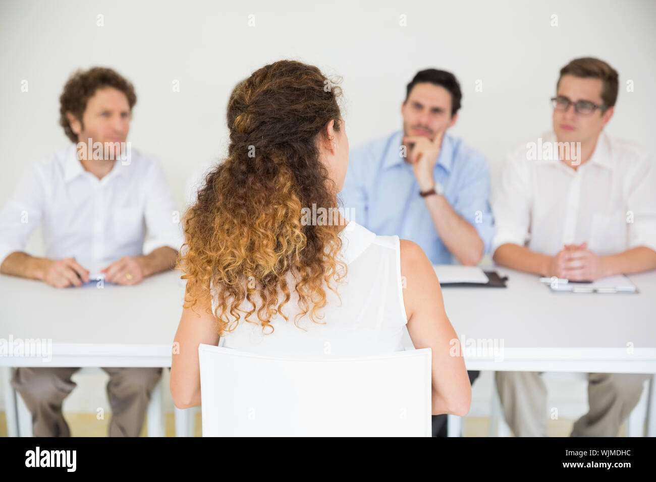 Panel of interviewers conducting job interview with female candidate ...