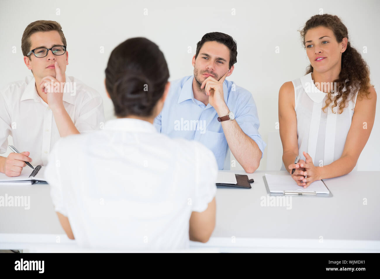 Panel of business people conducting job interview with male candidate ...