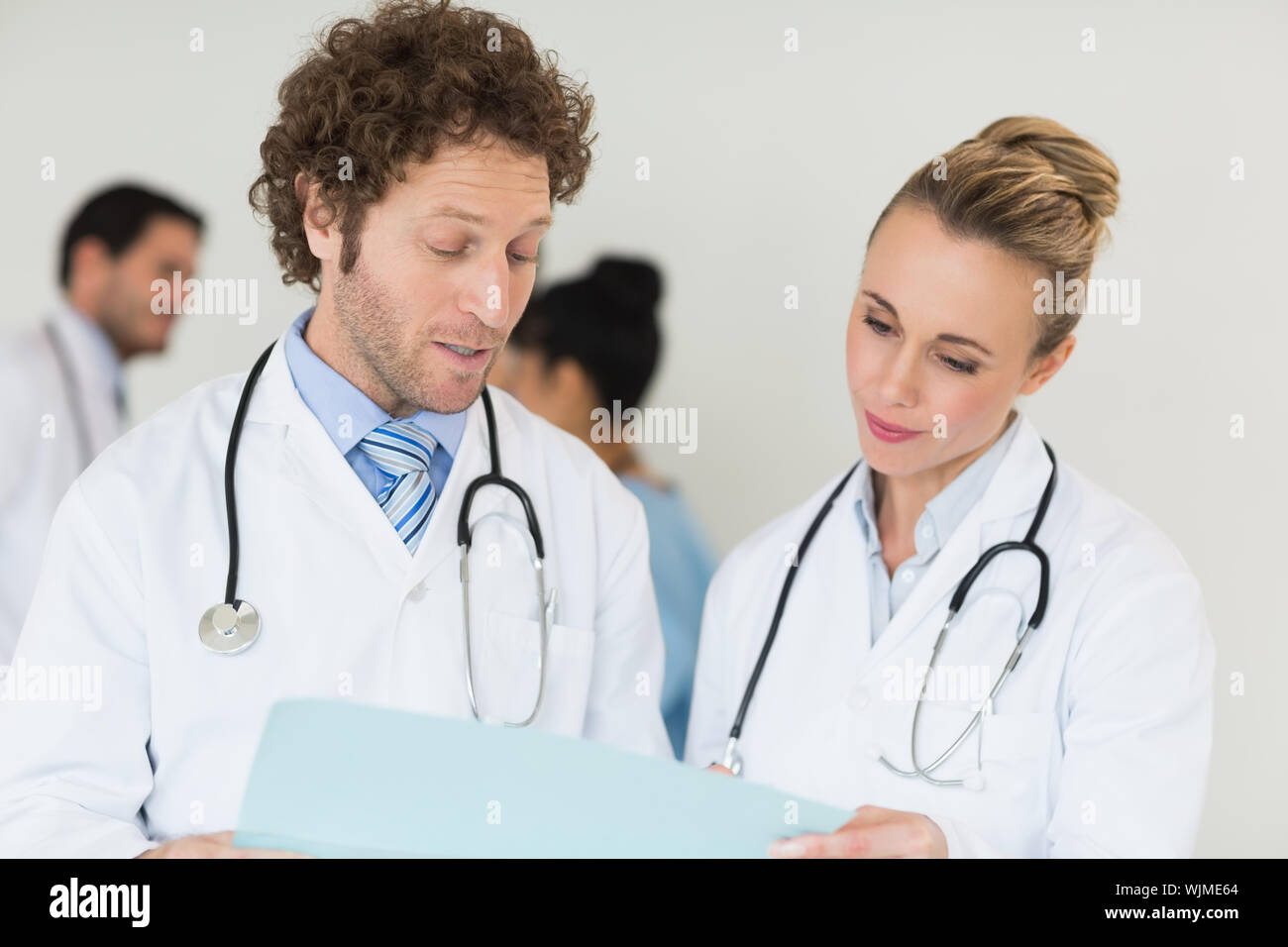Medical team discussing over file in hospital Stock Photo - Alamy